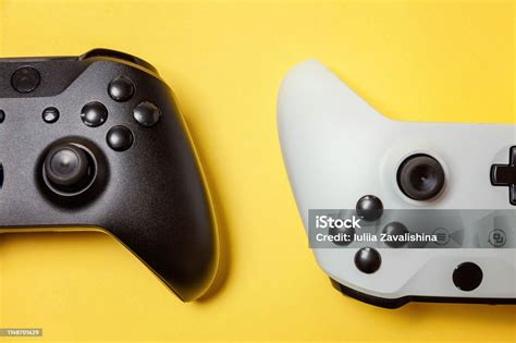 흰색 및 검은색 노란색 배경에 두 개의 조이스틱 컴퓨터 게임 경쟁 비디오 게임 제어 대결 개념 Brand Name Video