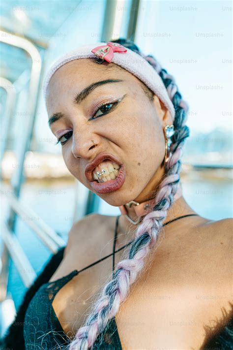 머리에 땋은 머리를 한 여자가 우스꽝스러운 표정을 짓고 있다 사진 Unsplash의 여자 이미지