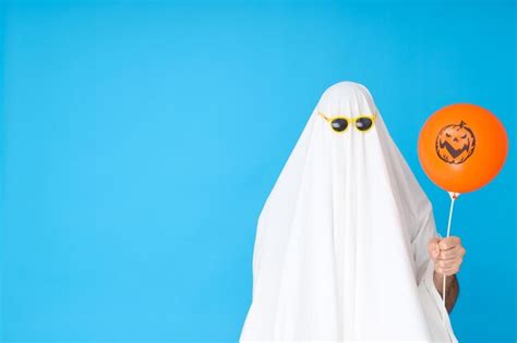 Premium Photo Concept Of Halloween Ghost In Sunglasses On Blue Background