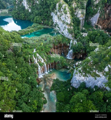 Aerial View Of Cascading Waterfalls And Turquoise Lakes Surrounded By