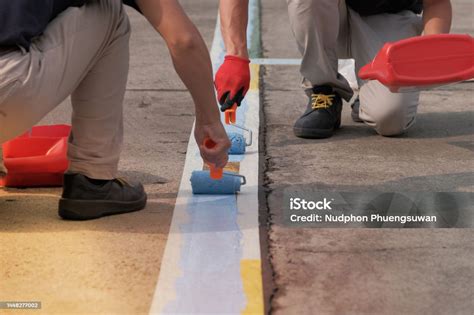 주차장 주차장의 콘크리트 바닥에 줄무늬가 있는 파란색 선을 그리기 위해 함께 작업하는 두 명의 화가 거리에 대한 스톡 사진 및 기타 이미지 Istock