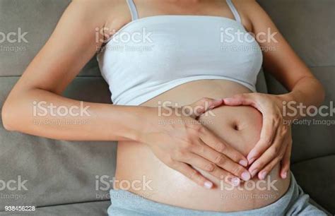 임신한 여자 피부에 스트레치 마크의 예방에 대 한 그녀의 배꼽에 크림을 적용 건강관리와 의술에 대한 스톡 사진 및 기타 이미지