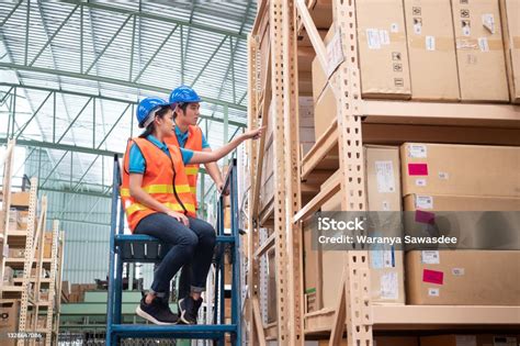 큰 창고에 있는 선반에 있는 재고에 대해 이야기하는 두 명의 노동자 창고에서 작업 저장고 일터에 대한 스톡 사진 및 기타 이미지 저장고 일터 창고 20 24세