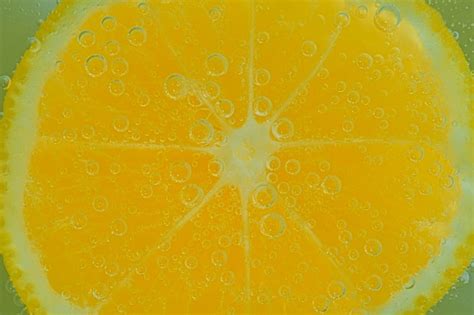 泡と液体中のレモンの接写スパークリングウォーターに黄色の熟したレモンのスライス炭酸水にジューシーな柑橘類マクロ画像 かんきつ類のストック