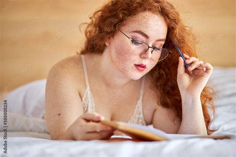 Pretty Half Naked Redhead Woman Make Notes Lying On Bed She Is Writing
