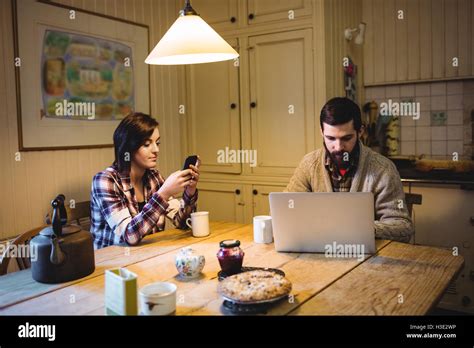 Couple Using Laptop And Mobile Phone Stock Photo Alamy