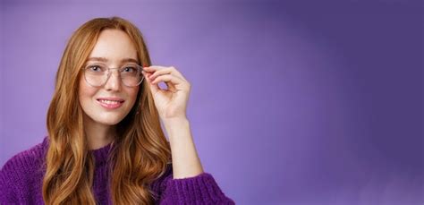 Linda Estudiante Nerd Con Hermoso Cabello Rojo Natural Tocando El Borde De Las Gafas Y Sonriendo