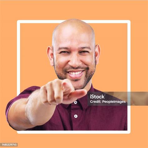 초상화 포인팅 그리고 주황색 배경에 스튜디오에 있는 흑인 남성과 함께 옵션을 선택합니다 얼굴 포인트 및 테두리와 잘 생긴 남성이