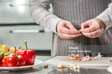 신선한 야채를 자르는 칼로 손의 클로즈업 화이트 도마 클로즈업에 마늘을 절단 젊은 요리사 레스토랑 주방에서 요리하기 건강한 생활