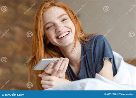 Redhead Woman Lying On The Bed With Smartphone Stock Photo Image Of Attractive Long