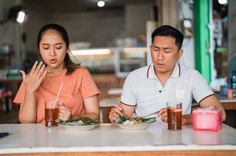 Asian Woman And Man With A Spicy Expression While Eating Stock Image