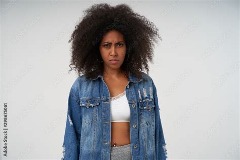 Portrait Of Angry Young Curly Dark Skinned Woman Posing Over White