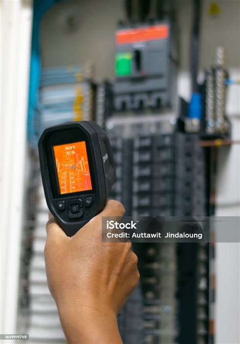 전문 전기 기술자는 예방 유지 보수 산업용 열화상 촬영 전력 전기의 열 이미지를 위해 열 적외선 카메라 또는 온도계 스캔 전기 시스템을 사용합니다 기술자에 대한 스톡 사진