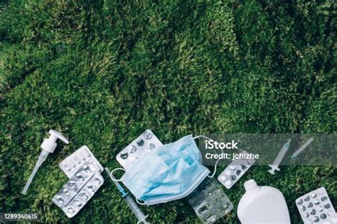 일회용 의료 용 얼굴 마스크 라텍스 의료 장갑 약물 커버 녹색 잔디 배경에 주사기 사용 맨 위 보기입니다 공간을 복사합니다 코로나바이러스 공증19 전염병 중 환경 오염 및