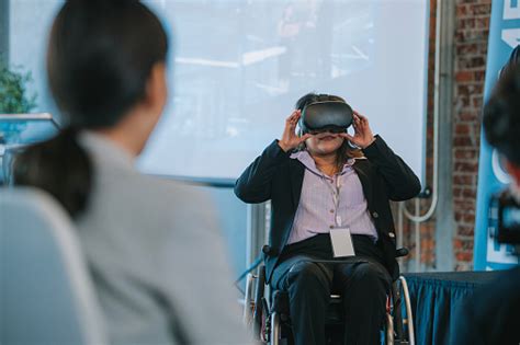 휠체어를 탄 아시아계 인도 여성이 컨벤션 센터에서 열린 비즈니스 컨퍼런스 세미나에서 Vr 고글을 시도하고 있다 인공지능에 대한
