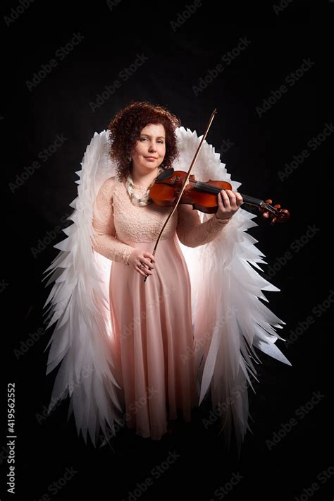 A Brunette Girl In An Elegant Dress With Violin And White Angel Wings