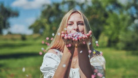 A Girl Blows A Multi Coloured Paper Confetti Out Of Her Hands Stock