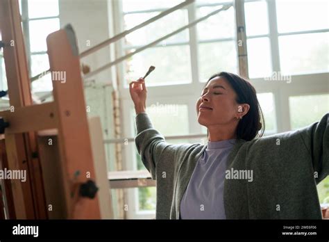 Smiling Woman With Eyes Closed And Arms Outstretched Standing In Front