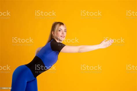 스포츠 복을 입은 젊은 여성이 흰색 고립 된 배경에 측면 굴곡합니다 측면 보기입니다 활동적인 라이프 스타일을 살고있는 소녀의