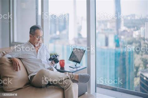 아시아 중국 은퇴 노인 휴식 에 거실 보고 그의 카메라 와 디지털 태블릿 거실에 대한 스톡 사진 및 기타 이미지 거실 고층