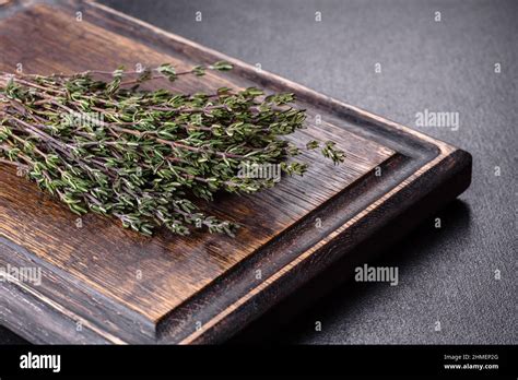 Bundle Of Fresh Thyme Grass On A Wooden Cutting Board On A Dark