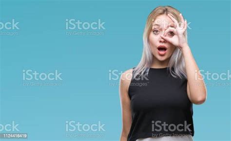 확인 제스처를 하 고 격리 된 배경 위에 젊은 금발의 여 자가 놀란된 얼굴 손가락을 통해 보고 눈으로 충격 믿지 않는 식입니다