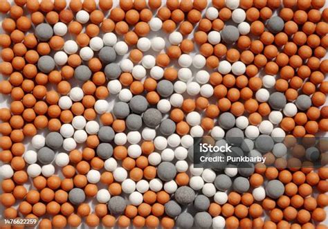 다양한 크기와 색상의 많은 작은 공이 주황색 배경에 흰색과 회색 패턴의 패턴을 만듭니다 0명에 대한 스톡 사진 및 기타 이미지 0명 갈색 개념 Istock