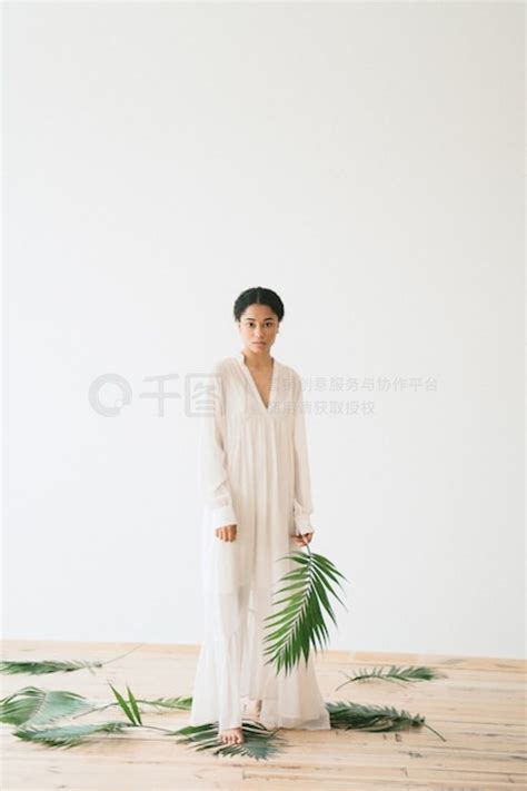 连衣裙高清图片 美丽的女士站在空荡荡的房间里穿着长长的白色连衣裙看着并拿着棕榈树枝文本空间 产品实拍免费下载 jpg格式 编号 千图网