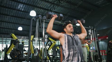 Asian Athlete Man In Sportswear Doing Seated Shoulder Press With