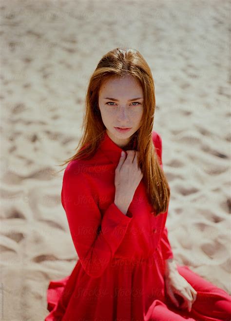 Portrait Of The Beautiful Woman In Red Dress Looking At Camera By