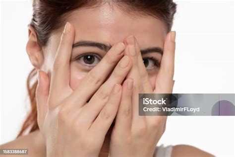 행복한 부끄러운 여자의 초상화 손으로 얼굴을 가리고 하얀 배경 위에 스튜디오에서 포즈를 취하는 아름다운 모델 20 24세에 대한