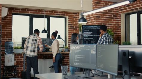 System Developers Analyzing Code On Wall Screen Tv Looking For Errors