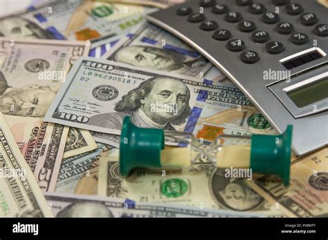 Hourglass Is On Dollar Banknotes And Calculator Lies On A Money
