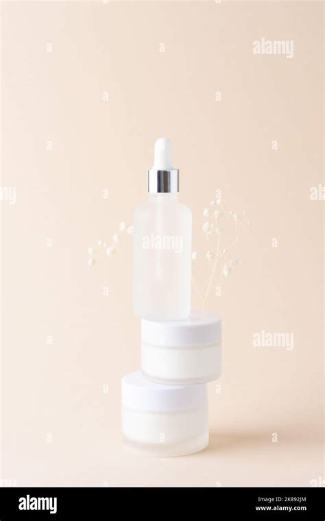 Cosmetic Skin Care Products And Flowers On Pastel Beige Background