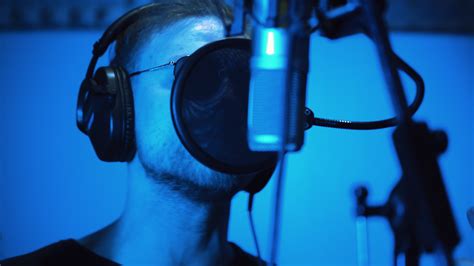 Male Rap Singer With Headphones Sings Hip Hop Into A Microphone