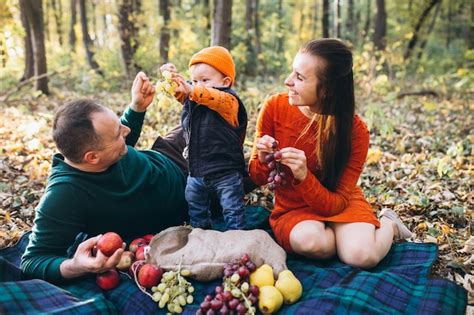 Familia con su pequeño hijo haciendo picnic en el parque Foto Gratis