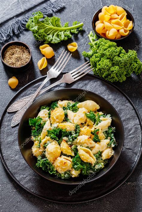 porción de pasta horneada con queso y col rizada verde cubierta con pan rallado crujiente en un