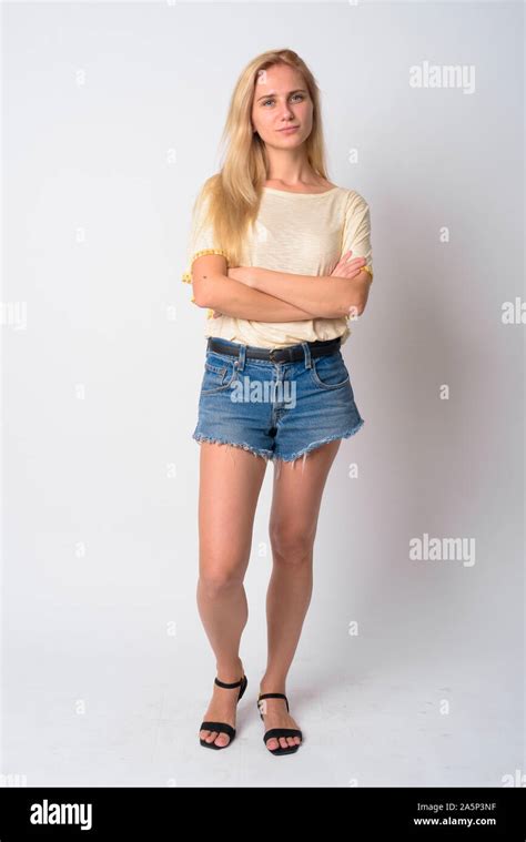 Full Body Shot Of Young Beautiful Blonde Woman With Arms Crossed Stock