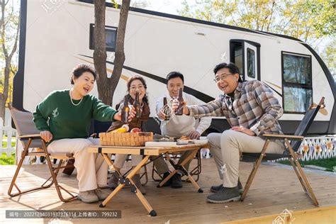 一群中老年人坐在房车露营地喝啤酒聊天摄影汇图网