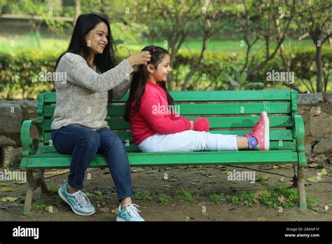 Madre E Hija Disfrutando En El Parque Rodeado De Vegetación Y Serenidad