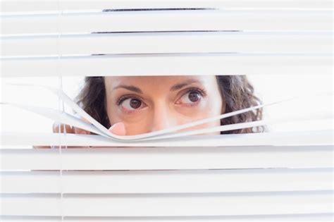 Premium Photo Curious Woman Looking Through Blinds