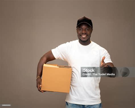깔끔하게 차려입은 흑인 미국인 배달원이 판지 상자를 들고 웃고 있습니다 30 34세에 대한 스톡 사진 및 기타 이미지 30 34세 공급망 깔끔한 Istock