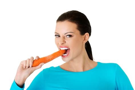 Premium Photo Portrait Of Smiling Young Woman Eating Carrot Against