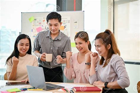 A Group Of Cheerful Asian Tech Developers Celebrating Their New Project Success Together Stock