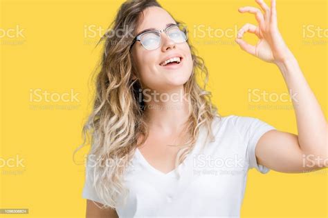 아름 다운 젊은 금발 여자 격리 된 배경 손과 손가락으로 Ok 사인을 하 고 긍정적인 미소에 안경 착용 성공적인 식입니다 곱슬 머리에 대한 스톡 사진 및 기타 이미지