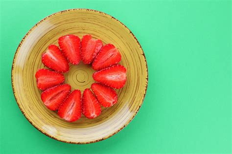 녹색 배경에 원 노란색 접시 아침 식사 채식 음식에 붉은 열매의 형태에 빨간 딸기의 반 딸기 복사 공간 디자이너 크리에이 티브에