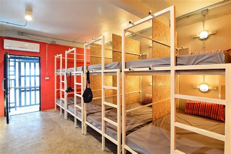 Bunk Beds Are Lined Up In A Room With Red Walls And Floor Tiles On The Wall