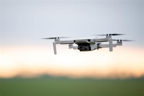 Premium Photo Quadcopter Hovering In The Air Above The Green Field On