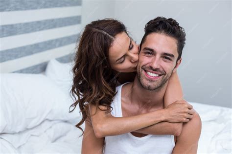 Premium Photo Wife Kissing And Embracing Husband On Bed
