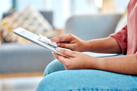 Premium Photo Woman Tablet And Wipe Screen For Dust Clean And Remove Bacteria In Living Room